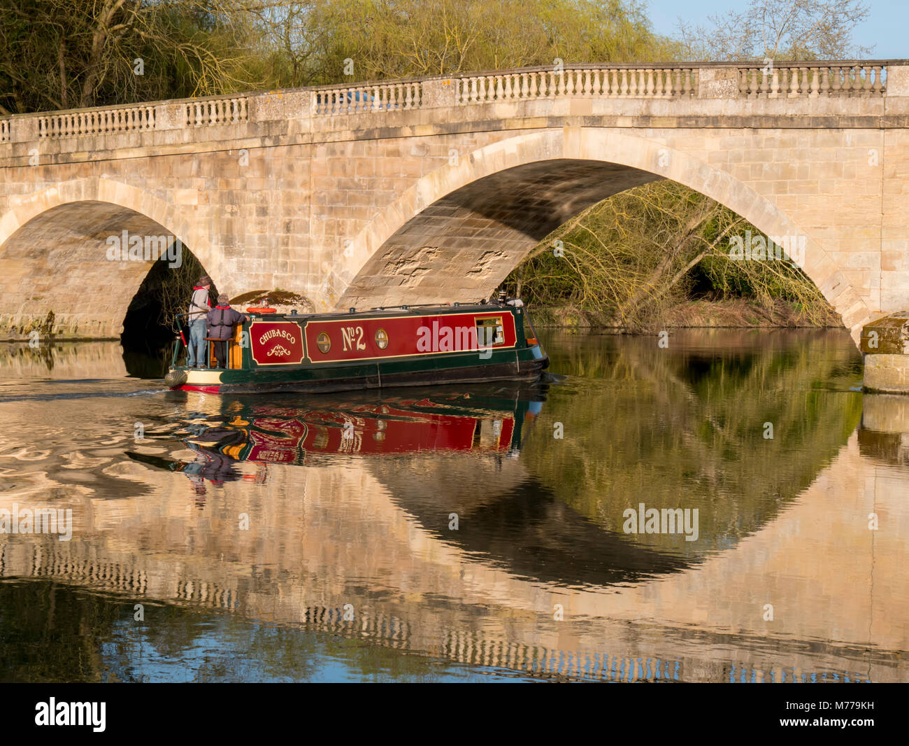 Red narrow boat passes under Shillingford Bridge reflected in River ...