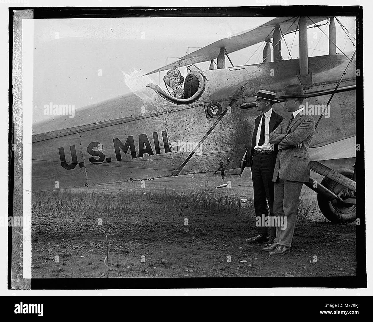 This photograph captures a U.S. Mail airplane, likely from the early ...