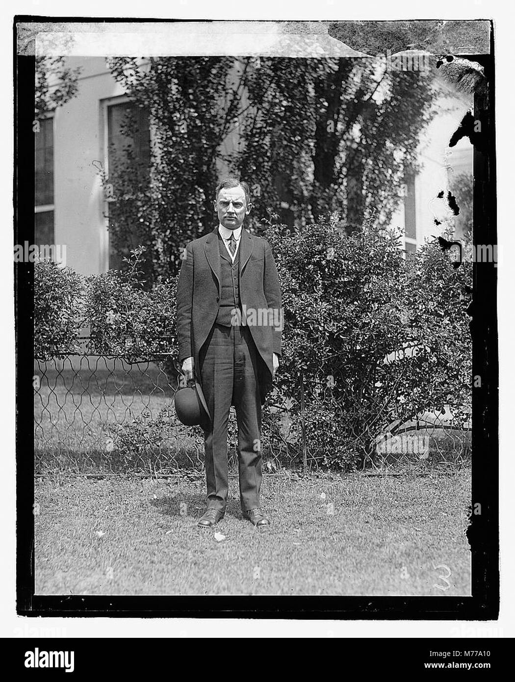A photograph of an unidentified man standing, offering a snapshot of an ...
