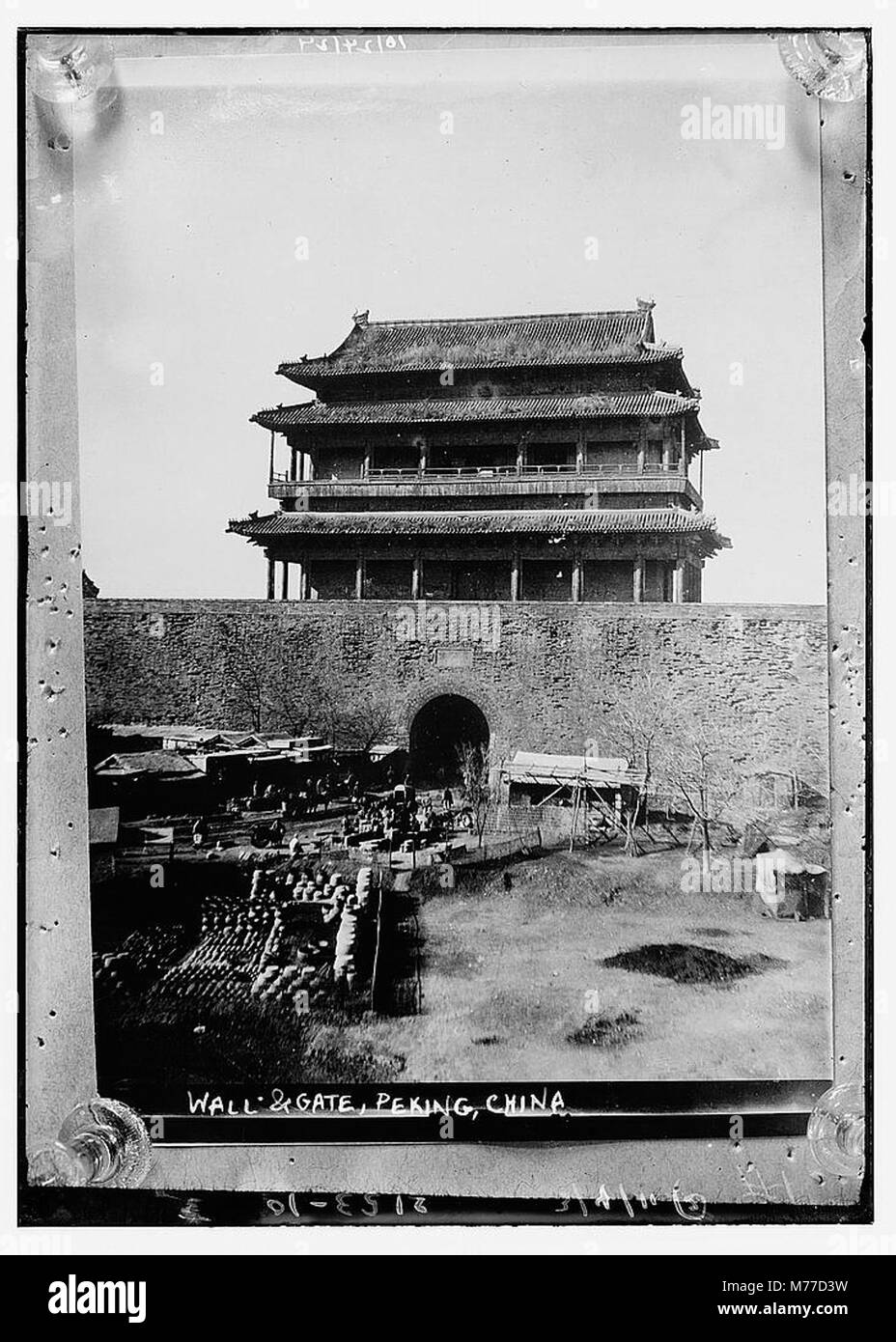 This image depicts the wall and gate of Peking (now Beijing), China ...