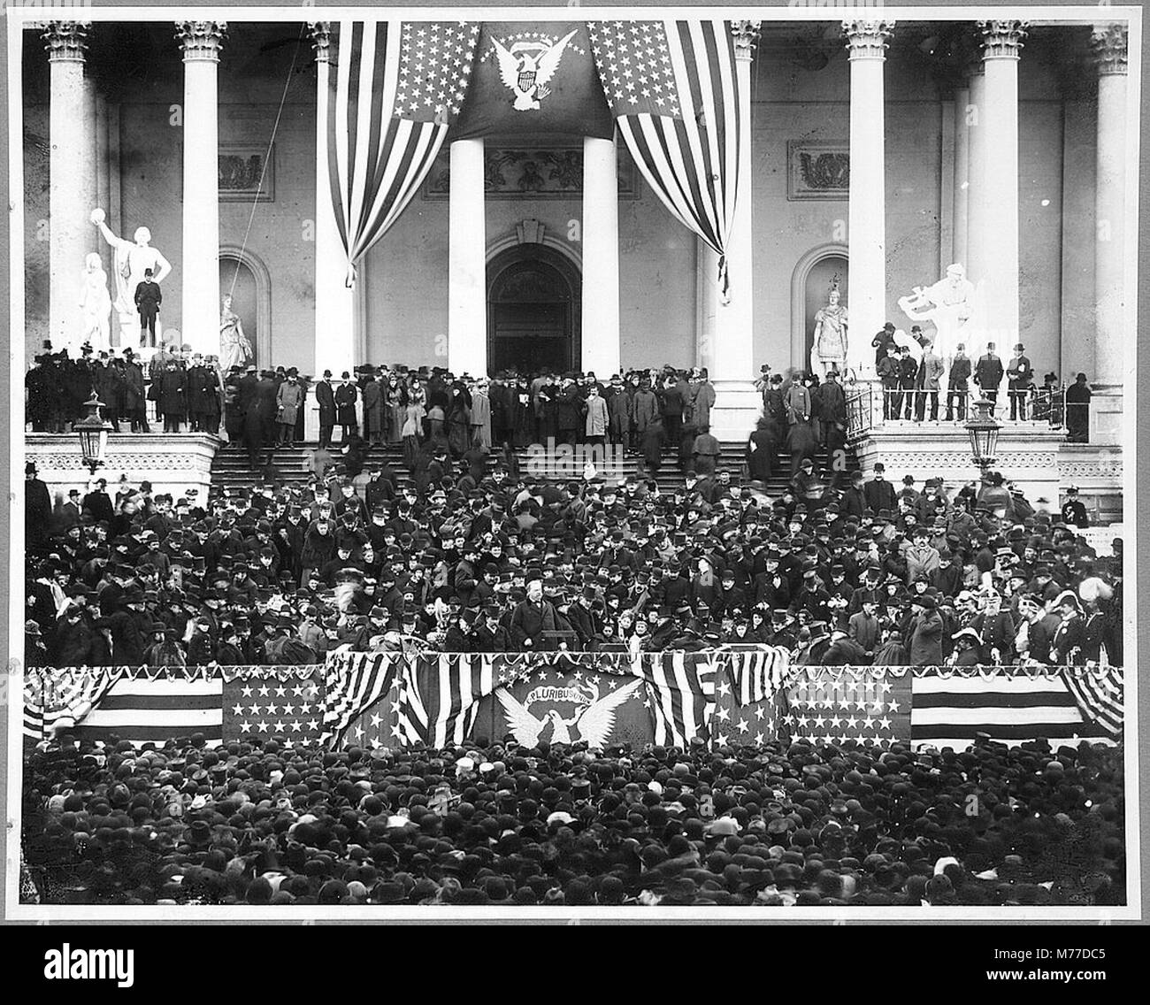 This photograph captures a crowd gathered in front of the U.S. Capitol ...