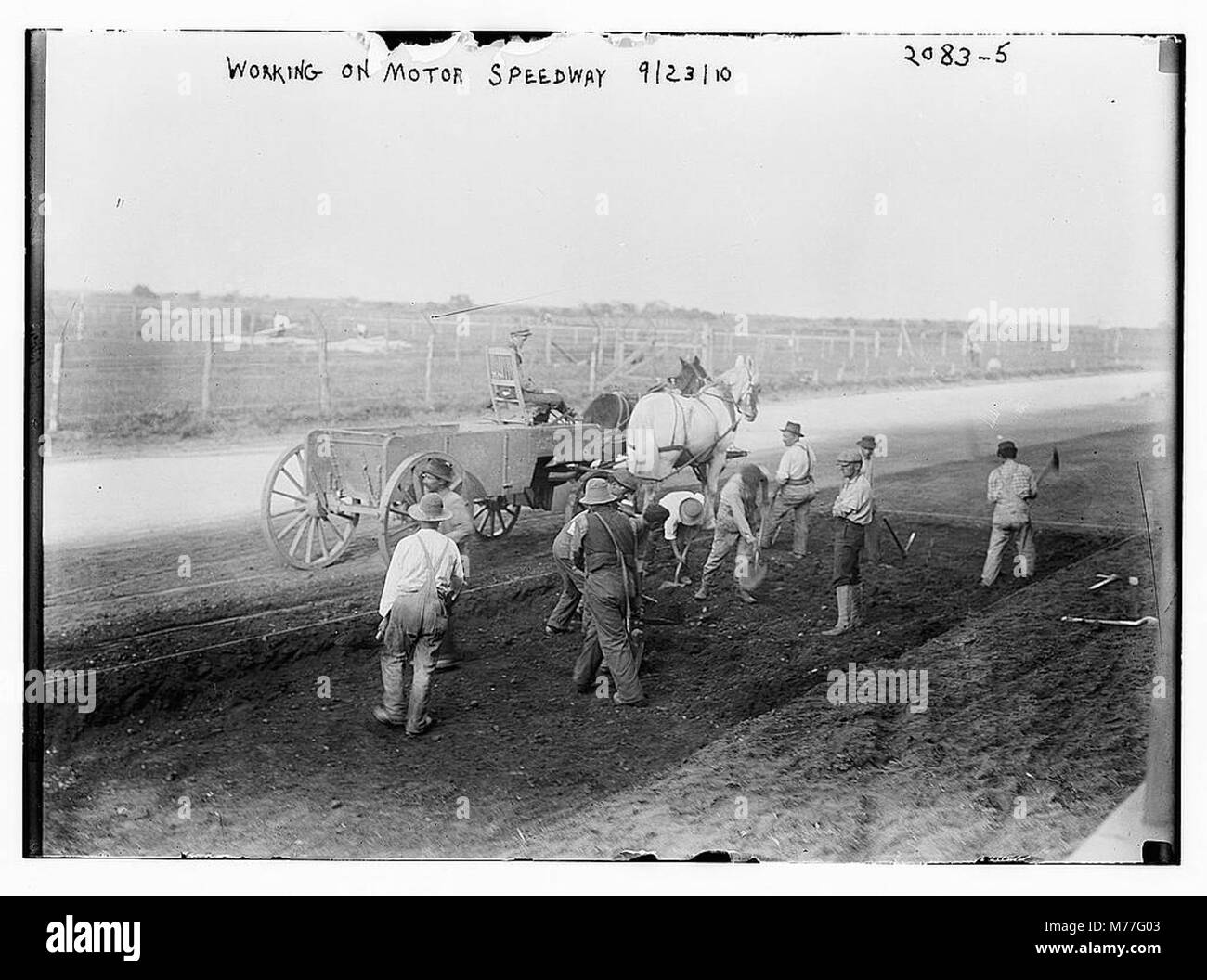A photo showing workers constructing a motor speedway, capturing the ...