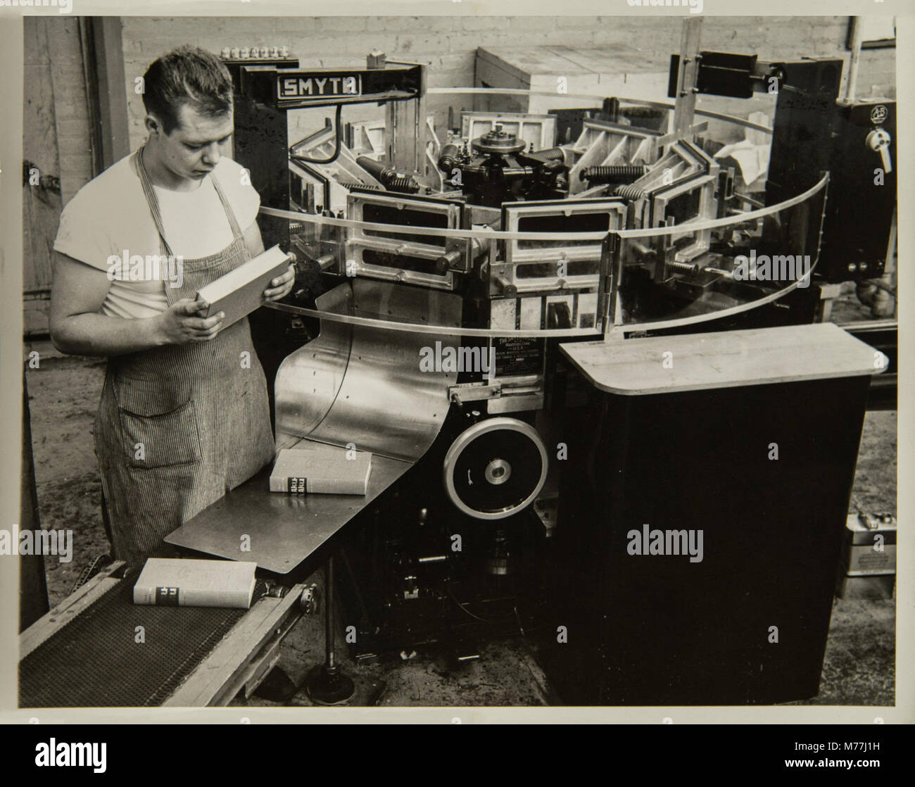 A photograph showcasing the process of book binding in a manufacturing ...
