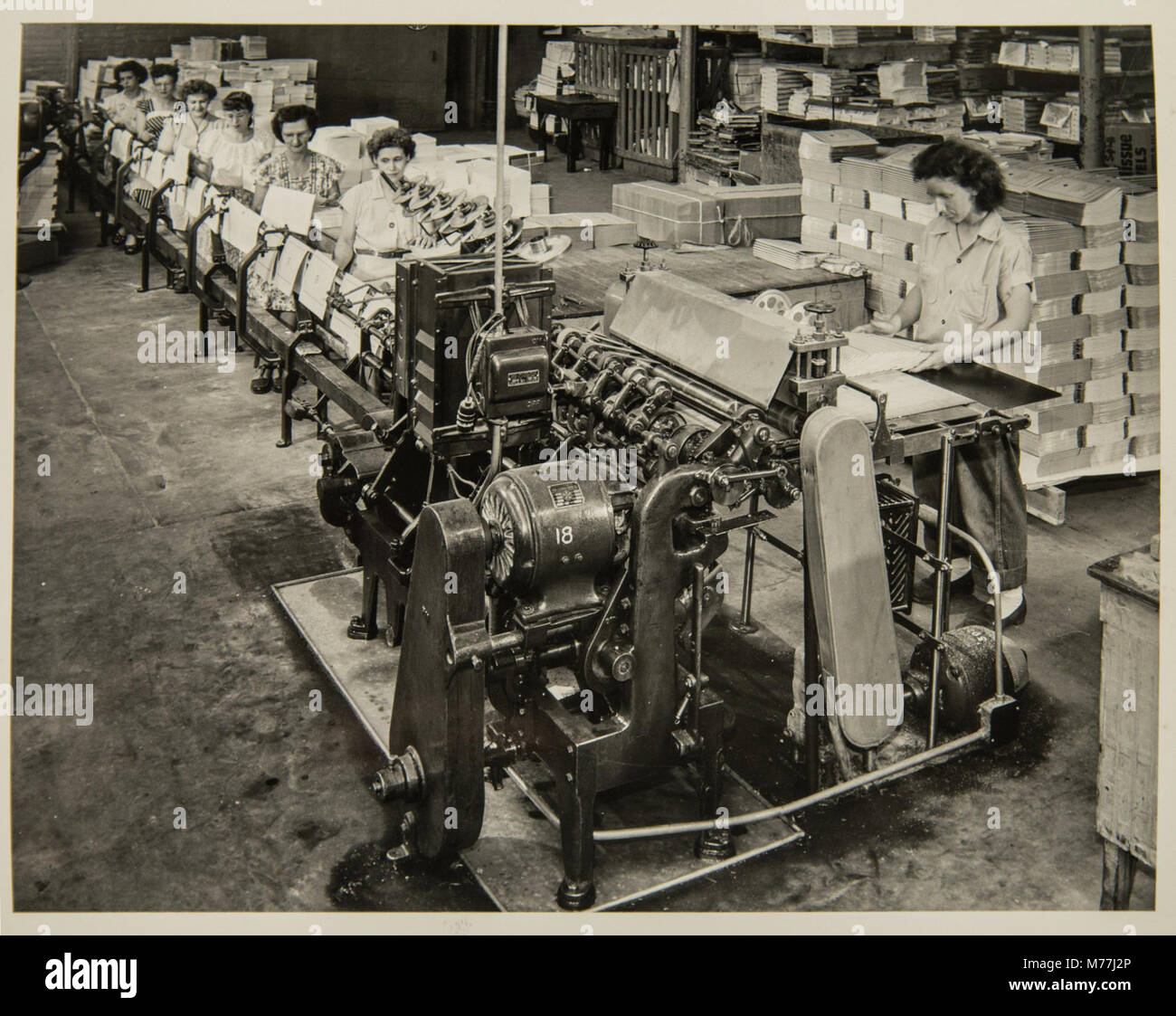 The image shows the process of book manufacturing, specifically the ...