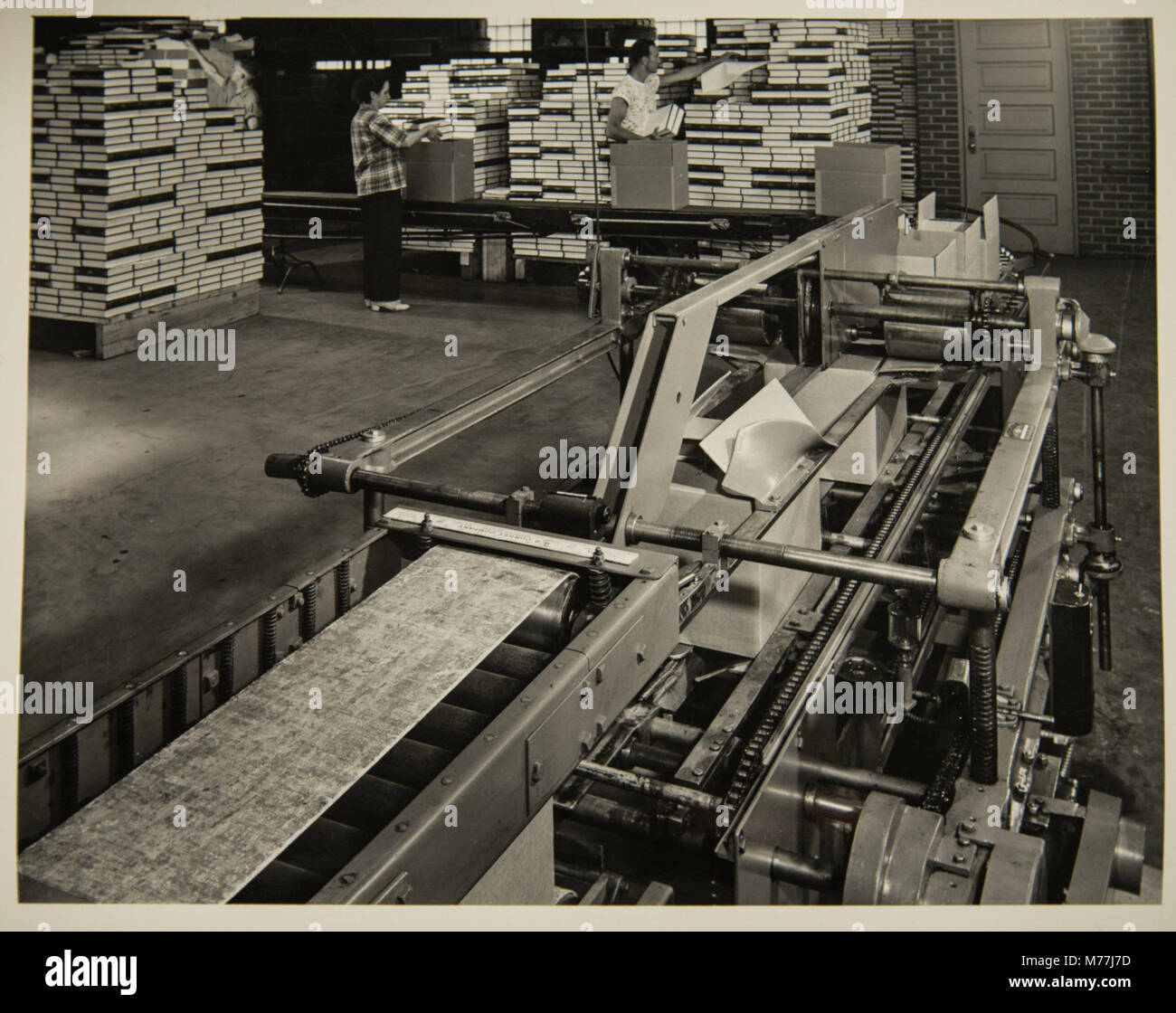 An industrial photograph showing the process of book manufacturing ...