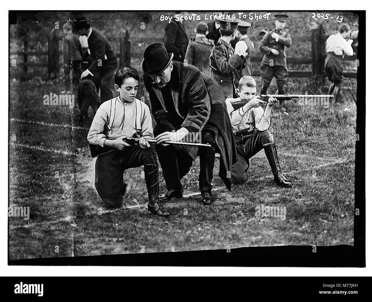 Boy Scouts are depicted learning to shoot under the guidance of an ...