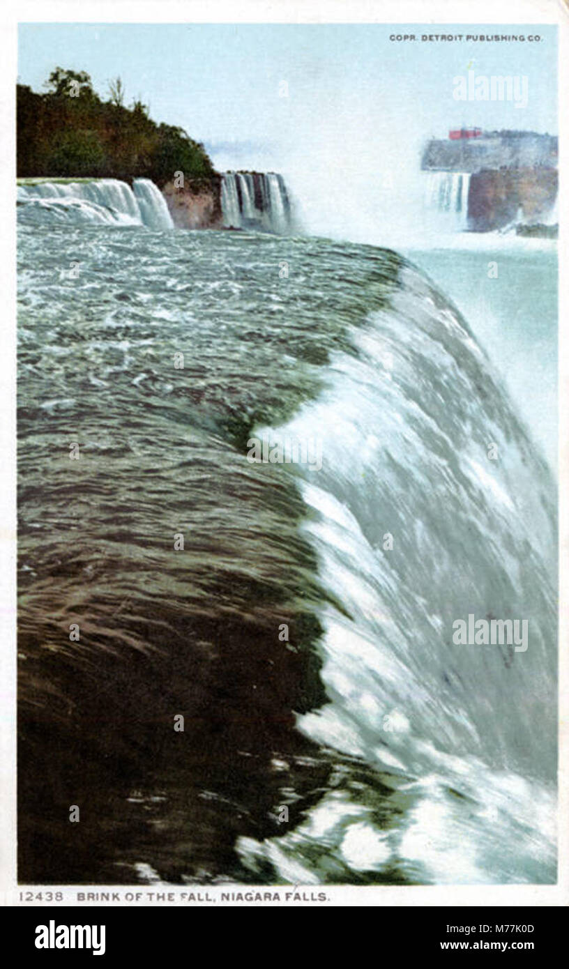 This photograph captures a dramatic view of the brink of a waterfall ...