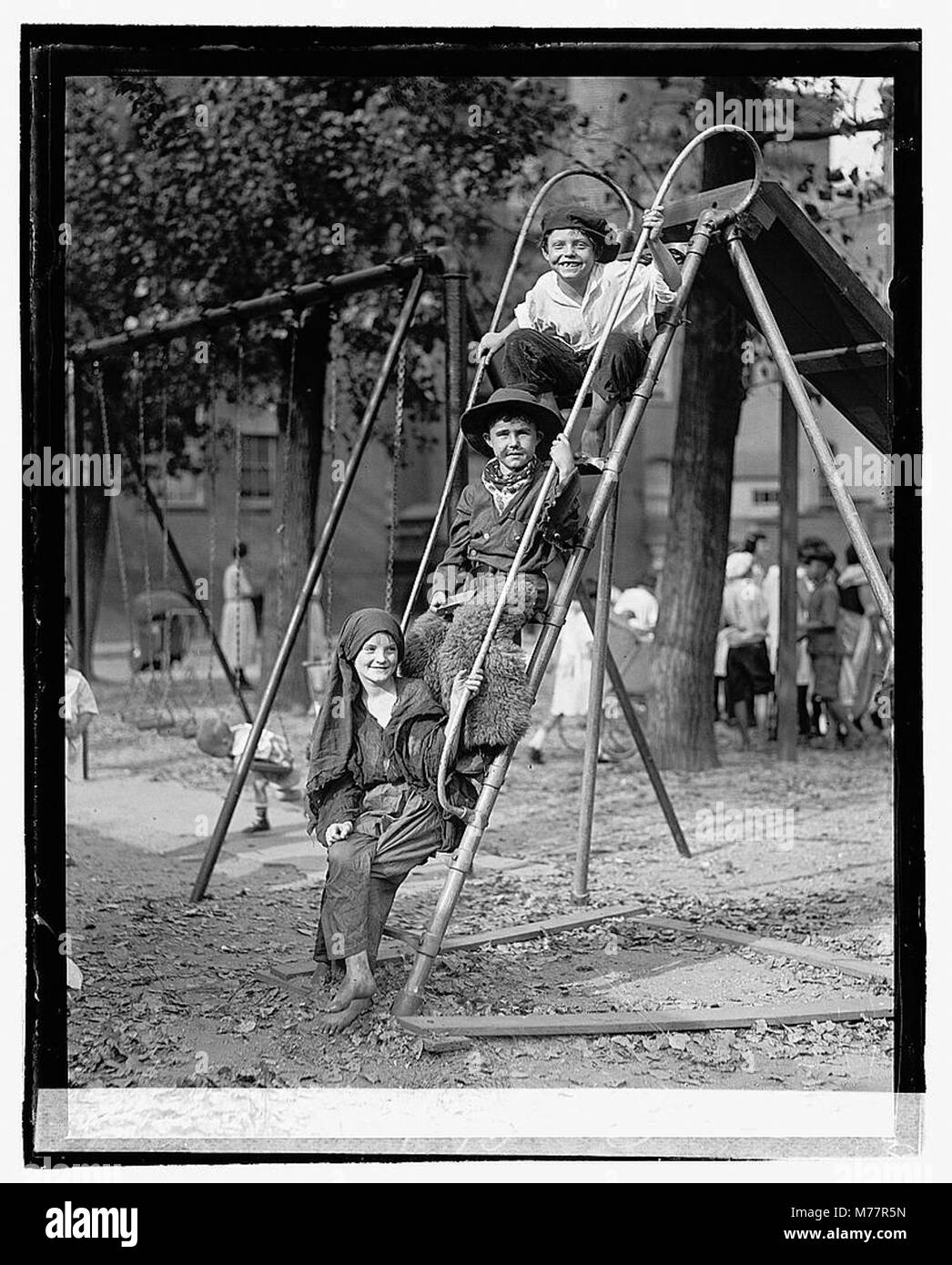 A photograph of children dressed in costume playing on a sliding board ...