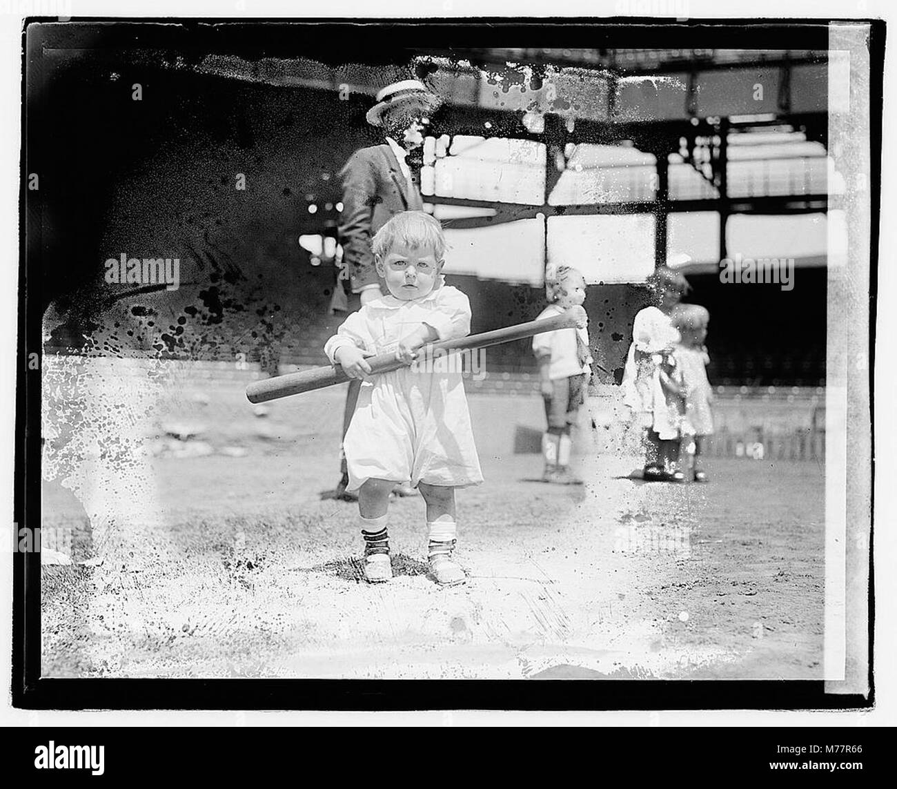 A photograph of children engaging in a game of baseball, a popular ...