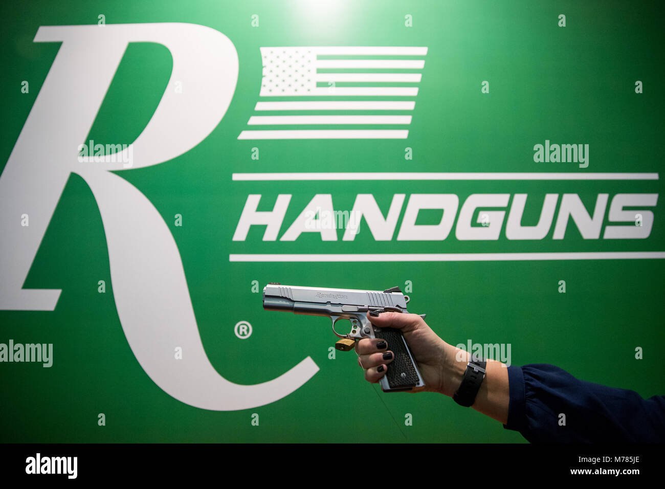 09 March 2018, Germany, Nuremberg: A woman holding a handgun by the ...