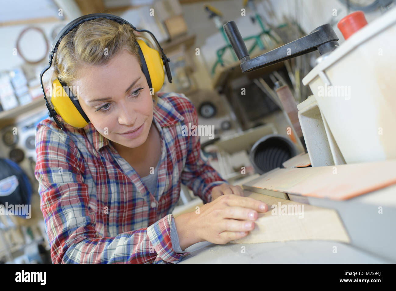 young female carpenter in safety equipment cutting wood Stock Photo - Alamy