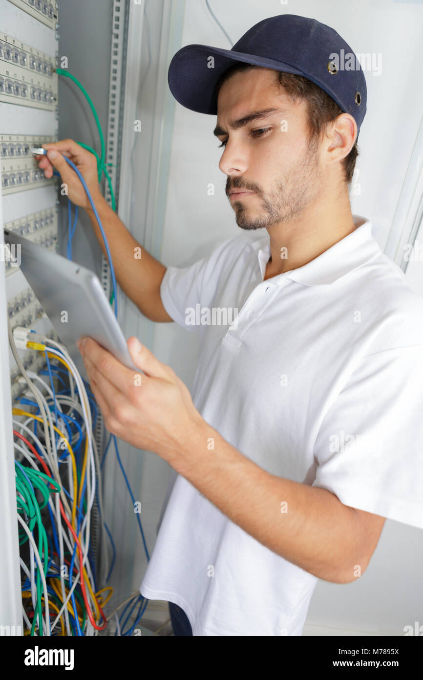 focused electrician applying safety procedure while working on ...