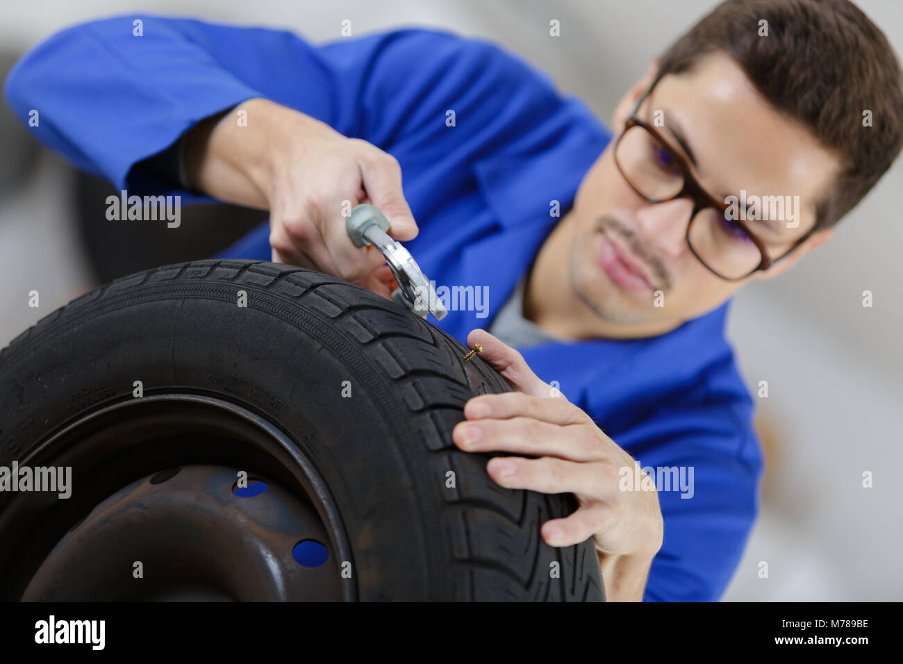 mechanic inspecting a wheel Stock Photo - Alamy