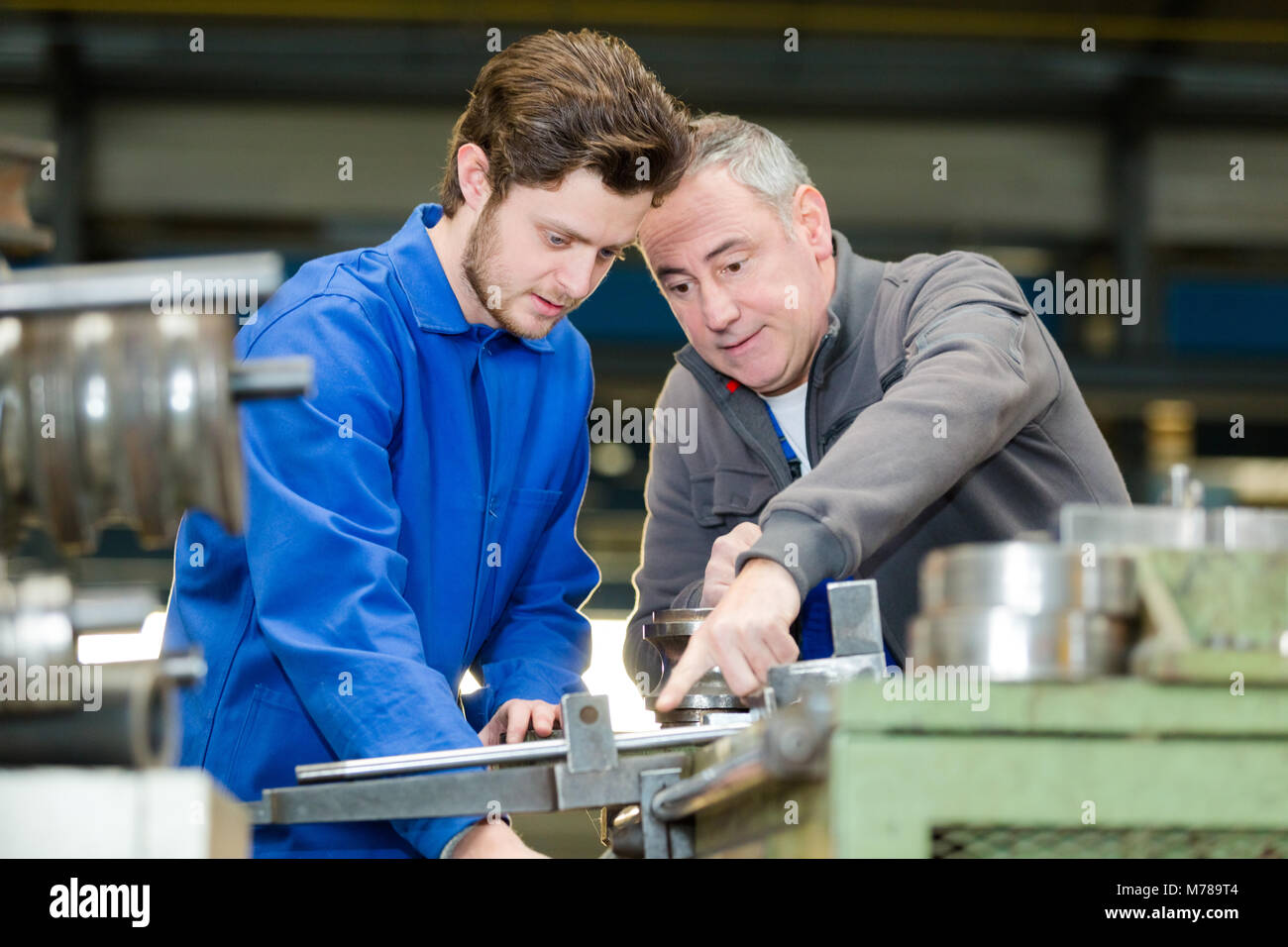 apprentice being shown how to cut sheet metal Stock Photo - Alamy