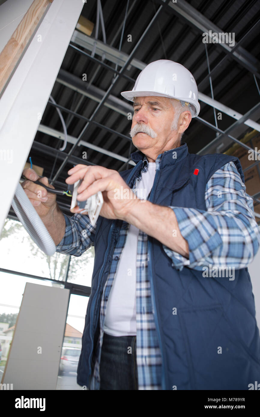 senior electrician wiring a wall socket Stock Photo - Alamy