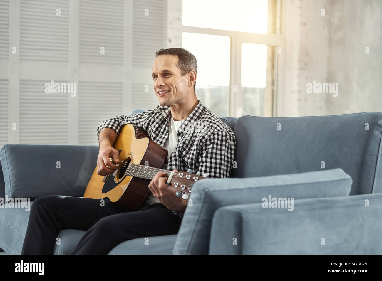 Alert man relaxing and playing the guitar Stock Photo - Alamy