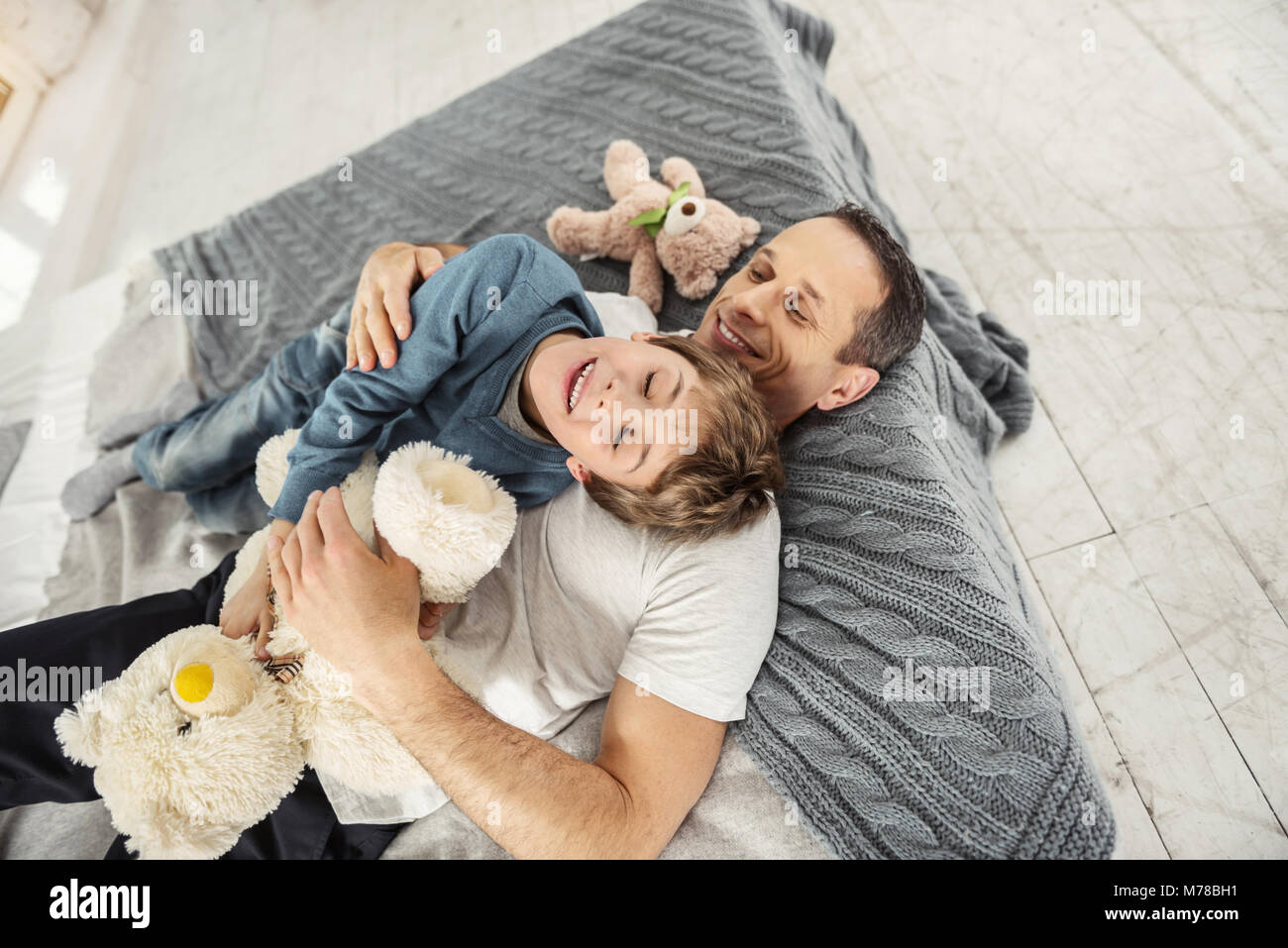 Inspired son and daddy relaxing on bed Stock Photo - Alamy