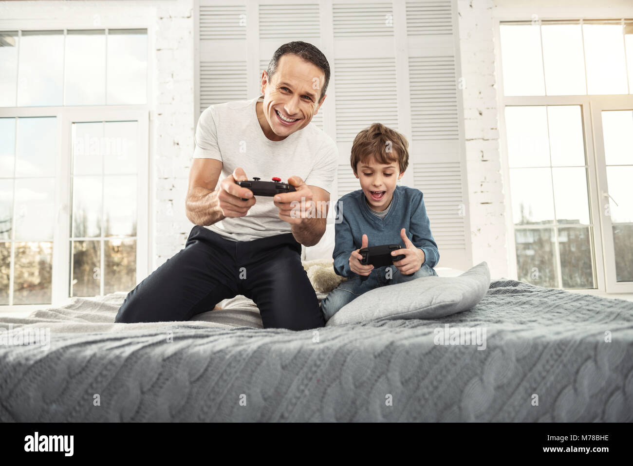 Cheerful dad and son playing games Stock Photo - Alamy