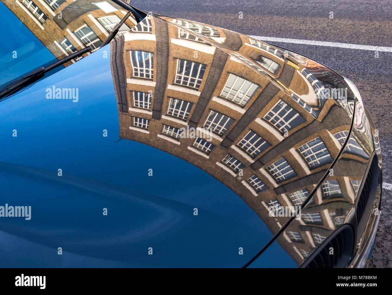 Car bonnet or hood and window with building reflected representing ...
