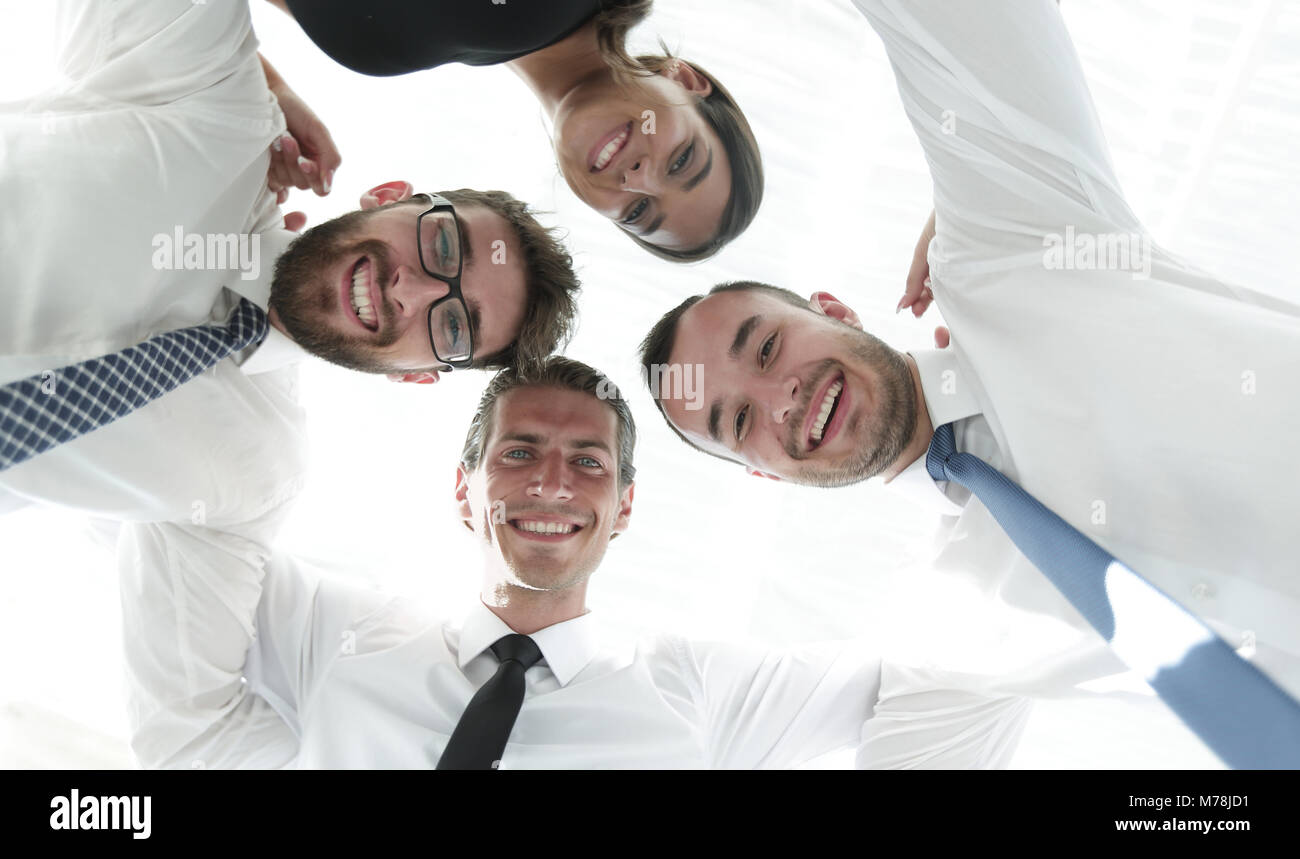 closeup.bottom view.successful business team with arms around each ...