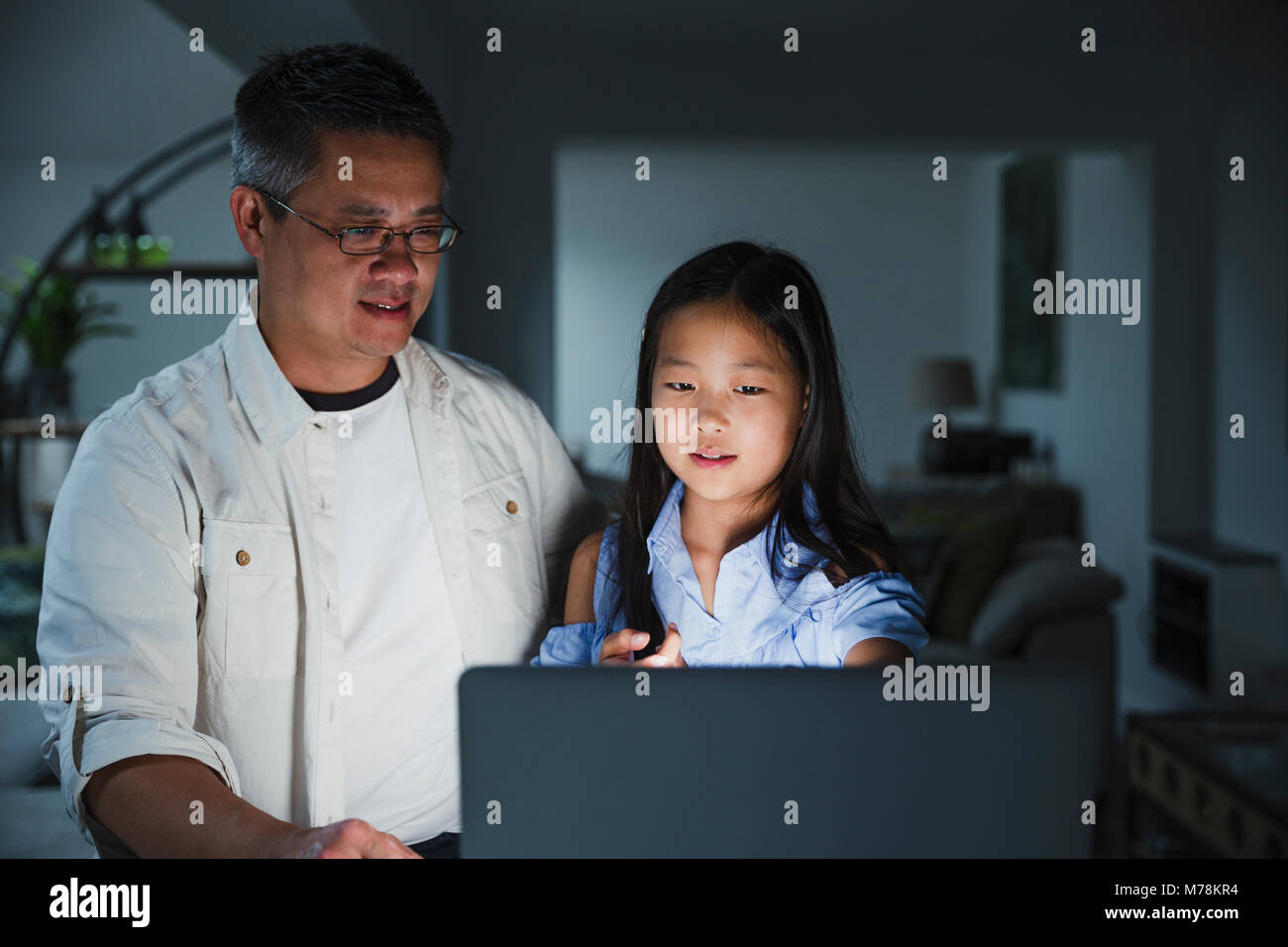 Little girl is getting help from her father while doing homework on the ...