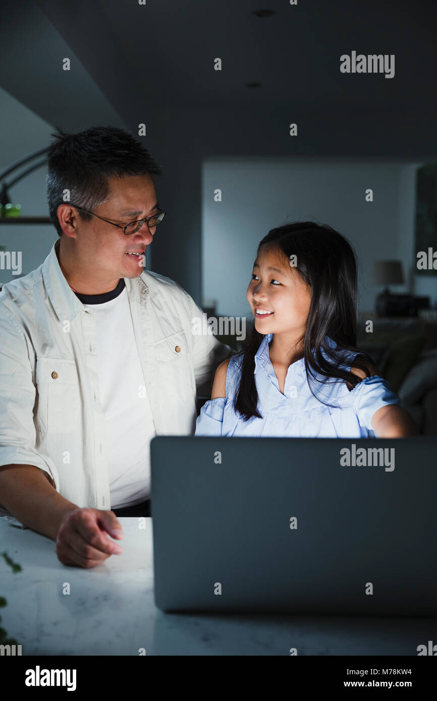 Little girl is getting help from her father while doing homework on the ...