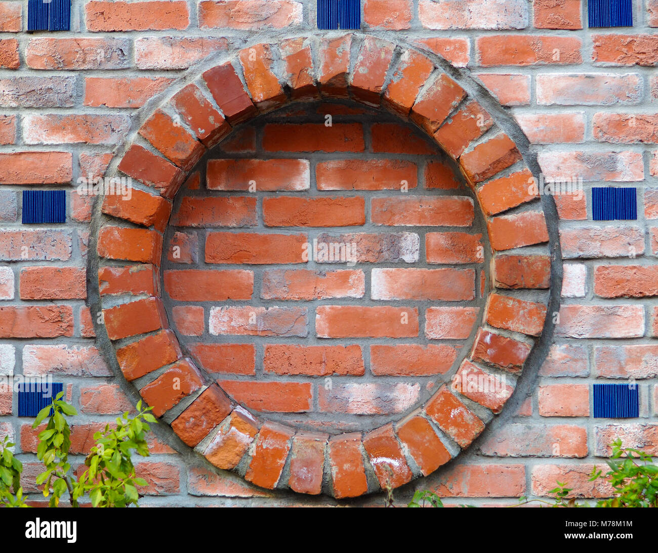 Round brick frame in wall, with ceramic blue tile highlights Stock ...