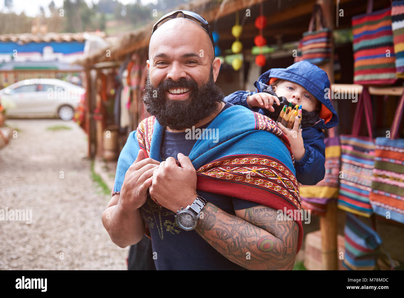 Man carry son in Alpaca cloth in local peruvian market. Family have fun ...