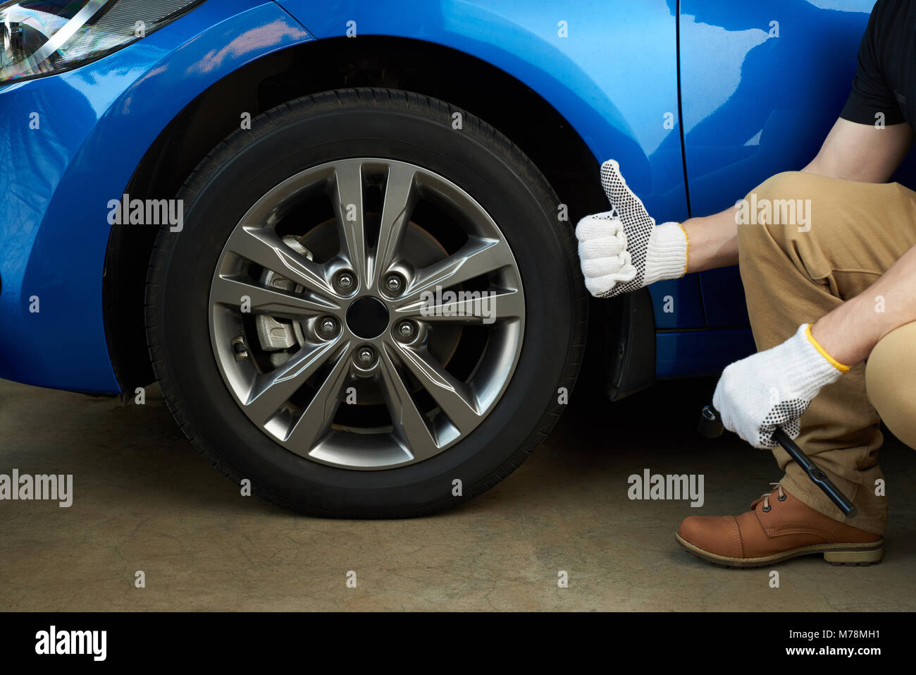Repaired car wheel. Car mechanic show thumb up Stock Photo - Alamy