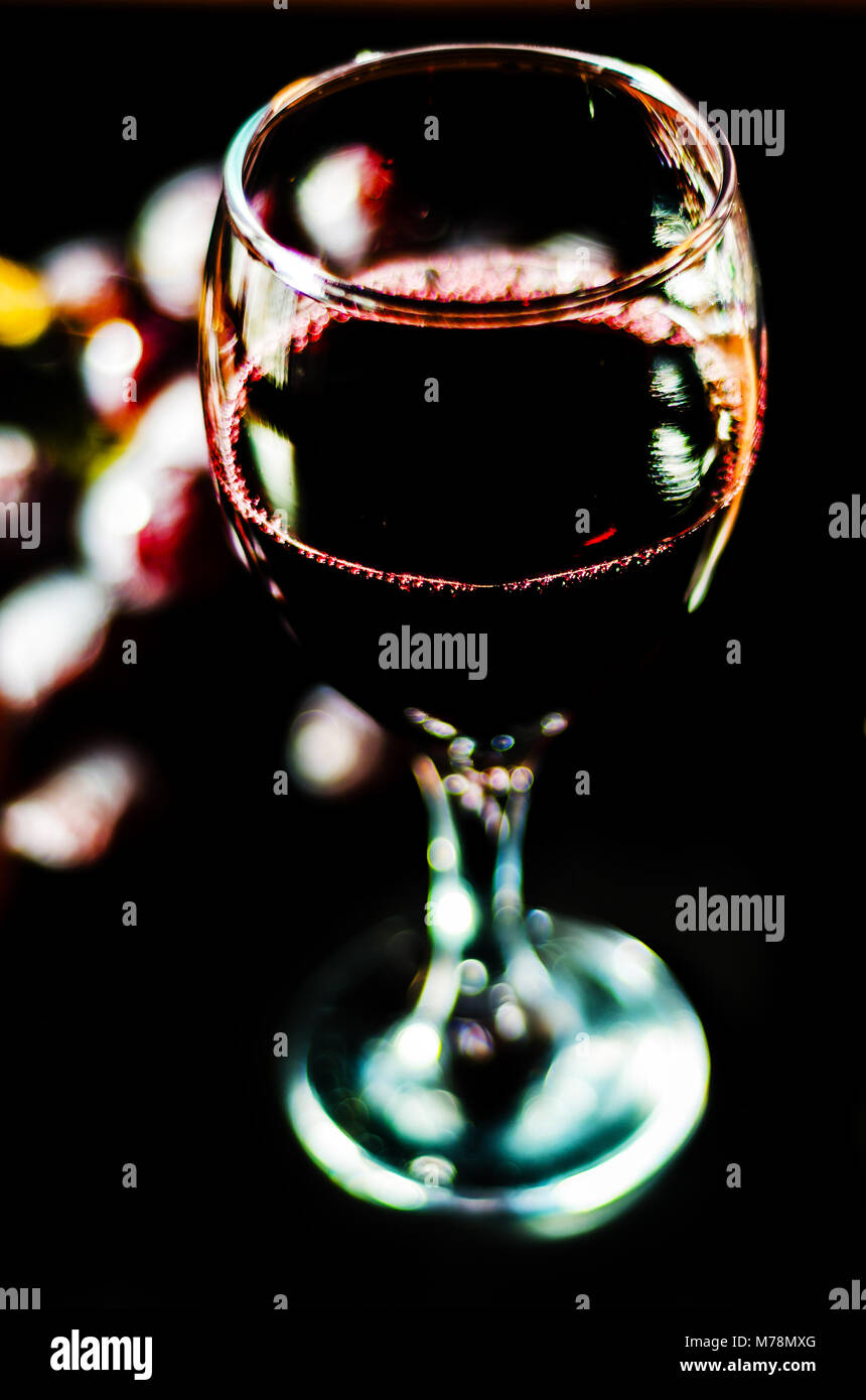 pouring red wine in a glass, celebration of a moment with a glass of ...