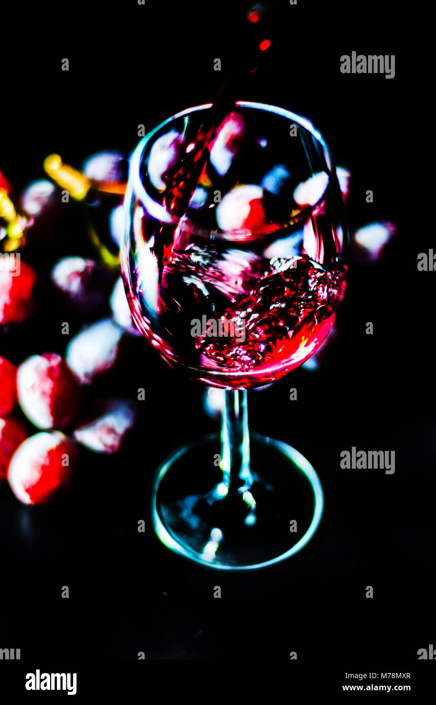 pouring red wine in a glass, celebration of a moment with a glass of ...