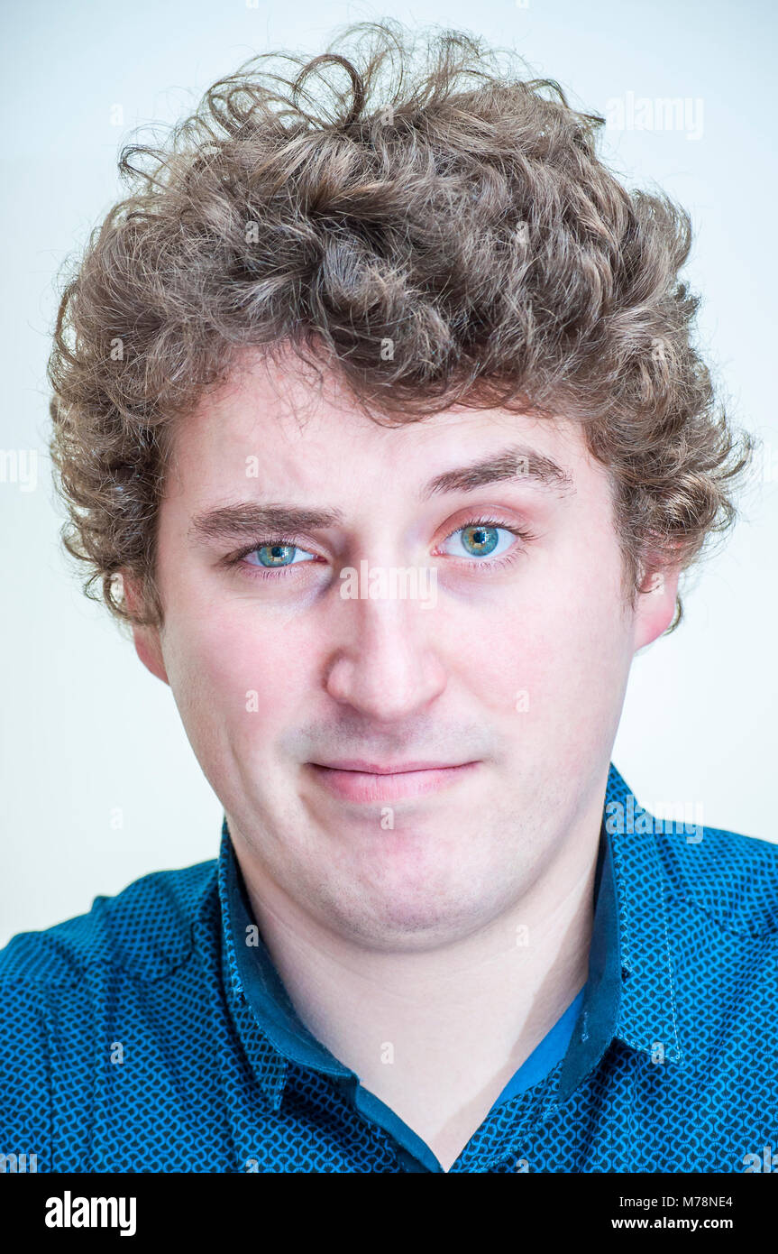 Portrait of young Caucasian Ethnicity curly man questionably ...