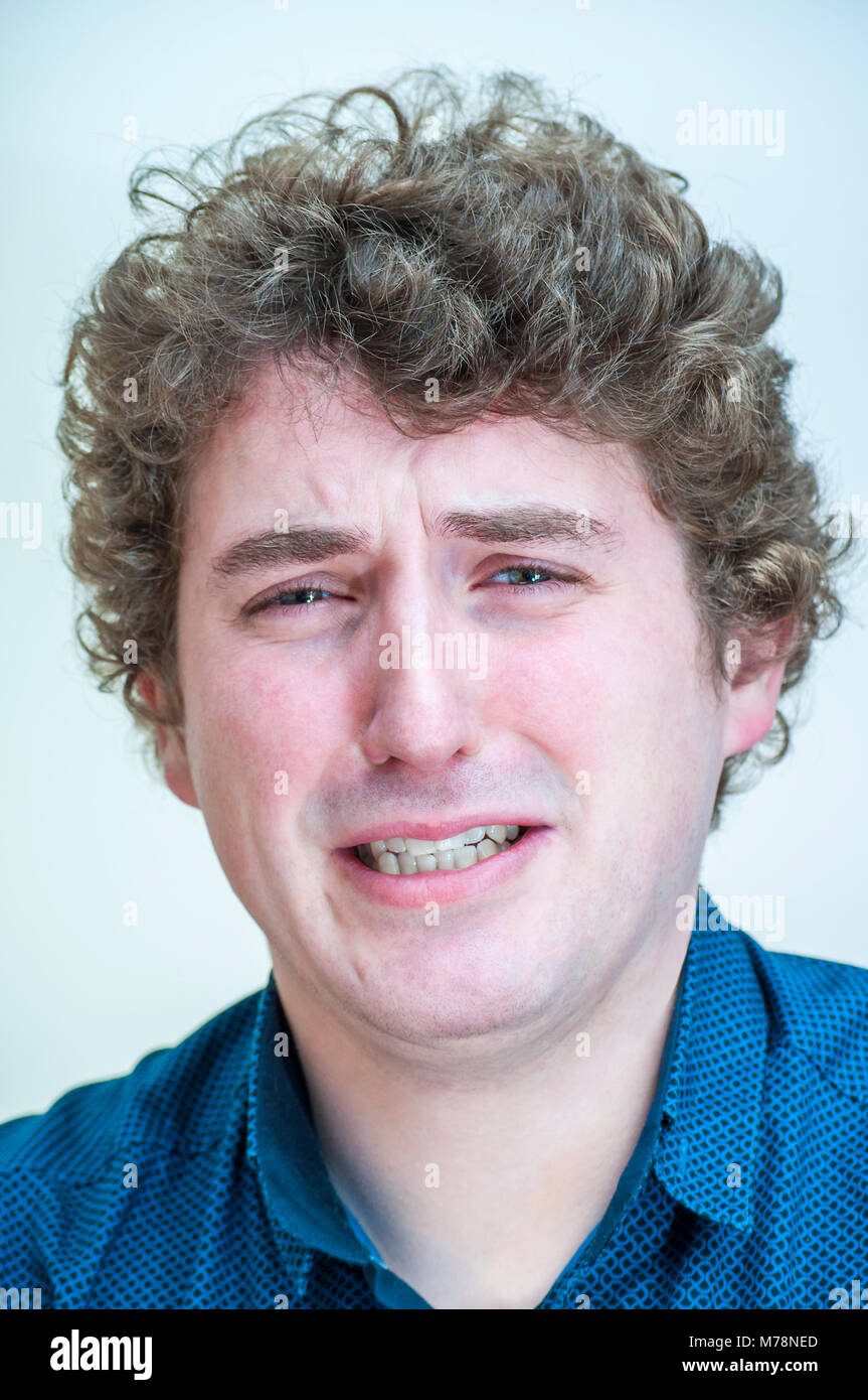 Portrait of young sad crying curly man on white background Stock Photo ...