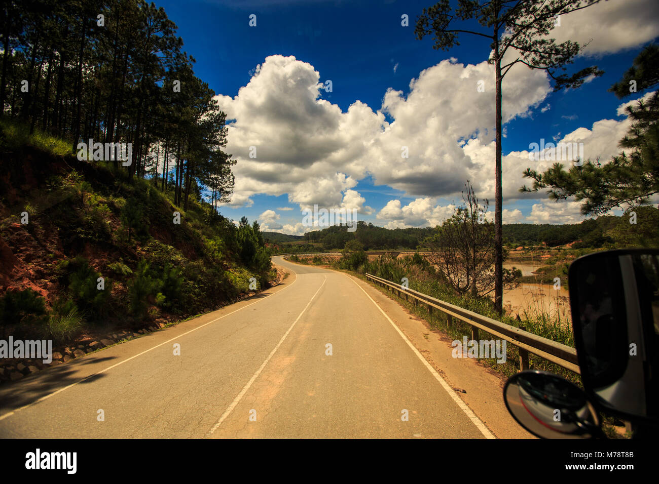 hilly rural country scape with warm-houses and high trees out of bus ...
