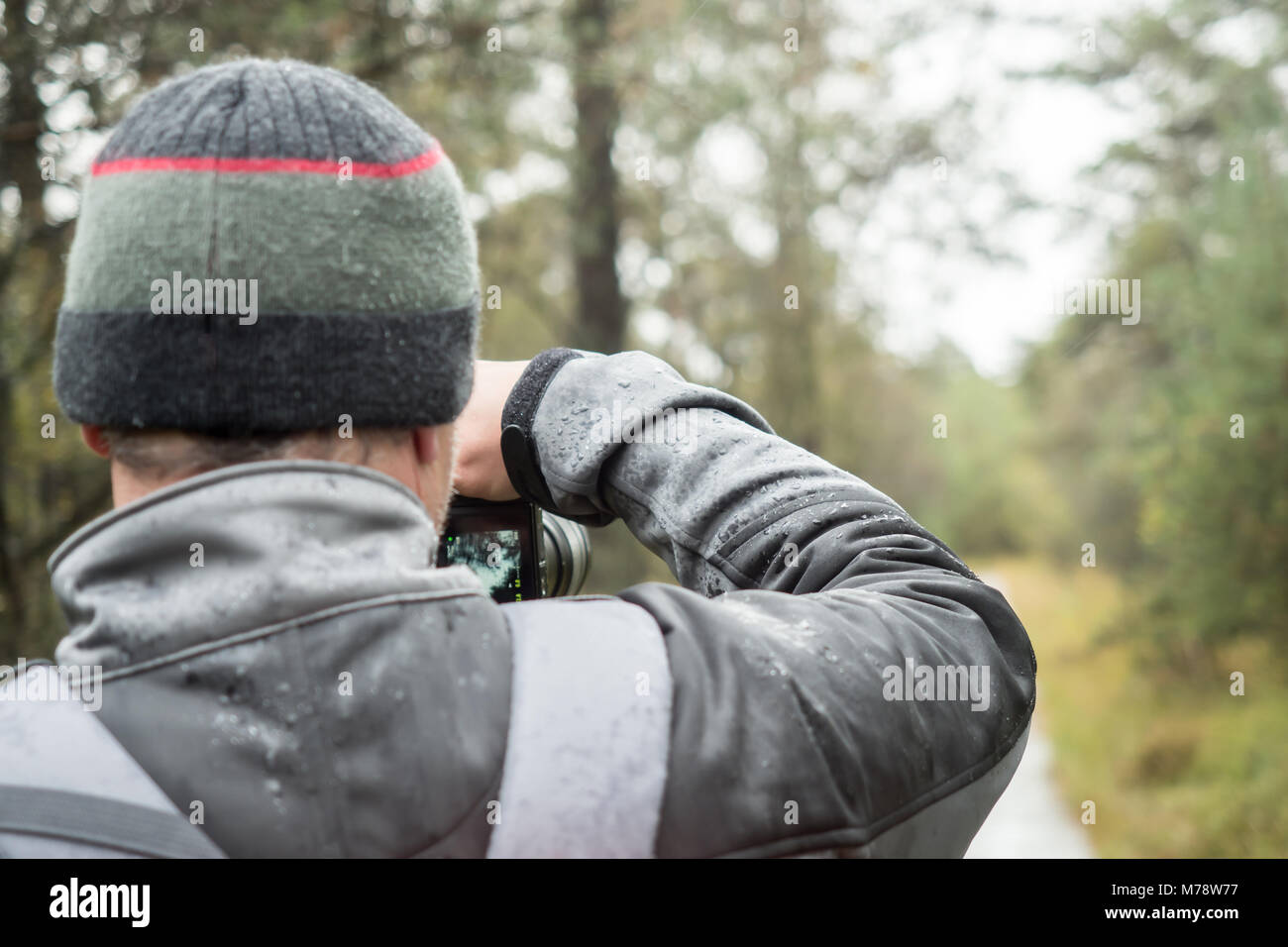 A photographer with a camera in the rain Stock Photo - Alamy