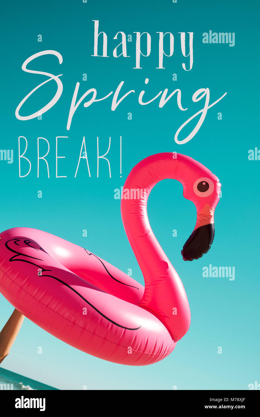 closeup of a young man on the beach holding a swim ring in the shape of ...