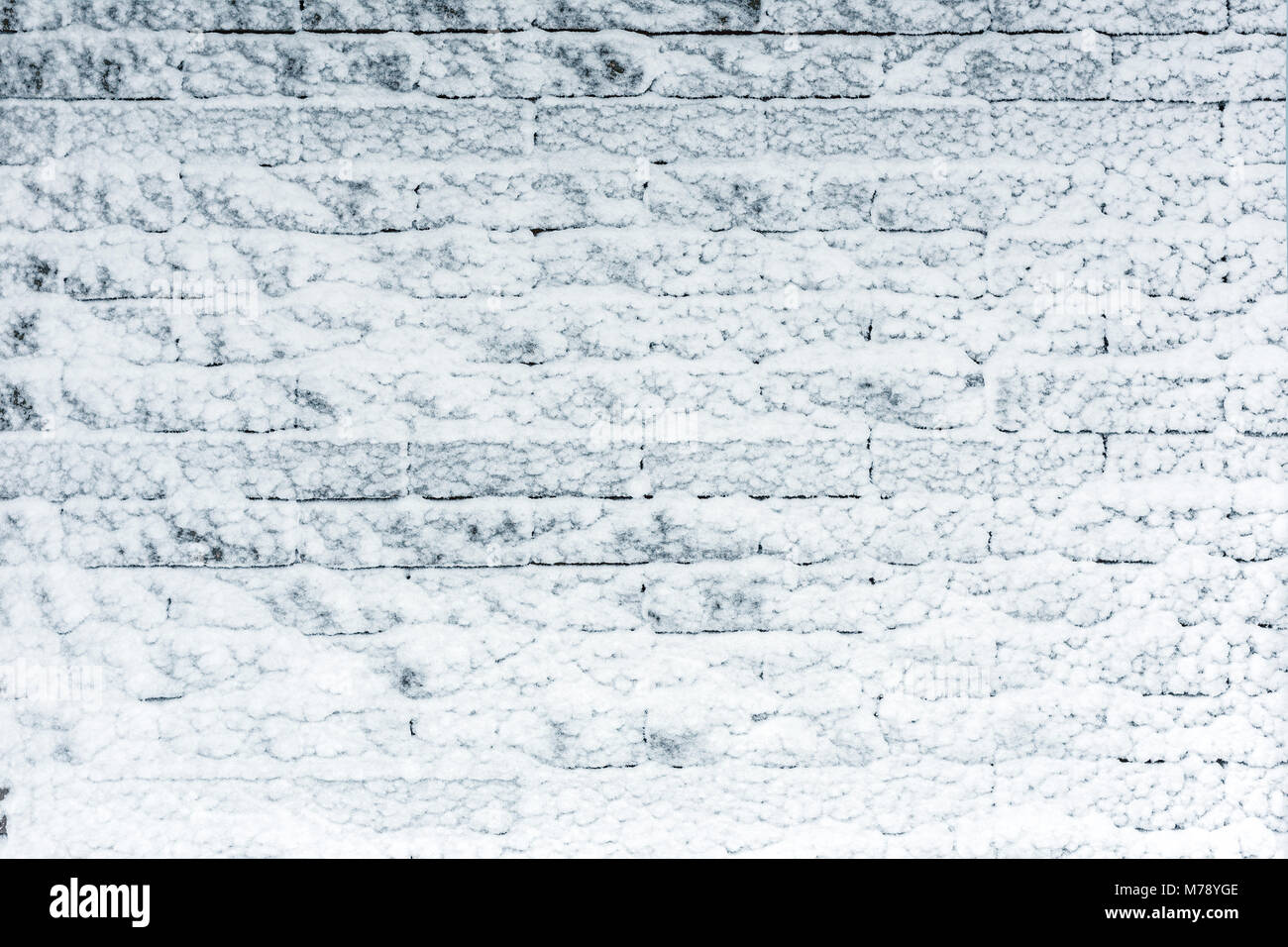 Brick wall covered with light blue snow. Iced winter surface texture ...