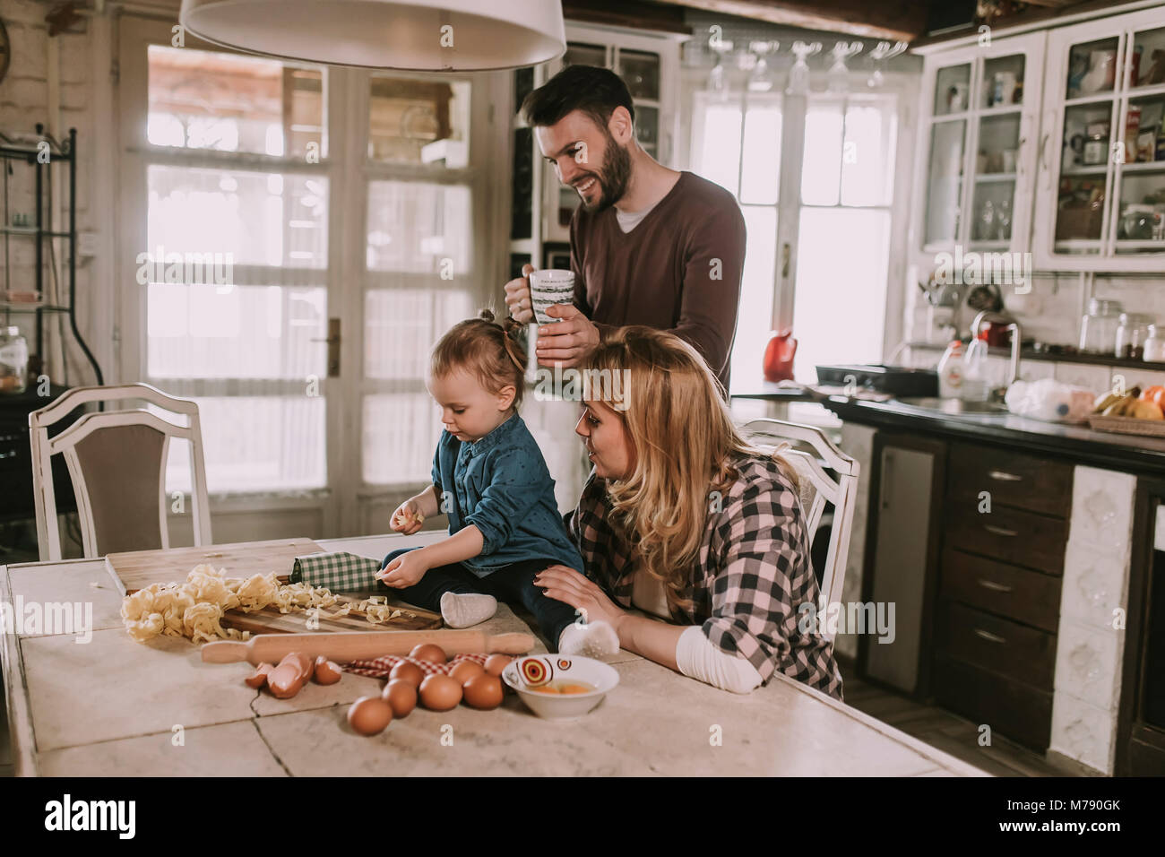 Happy family making pasta in the kitchen at home Stock Photo - Alamy