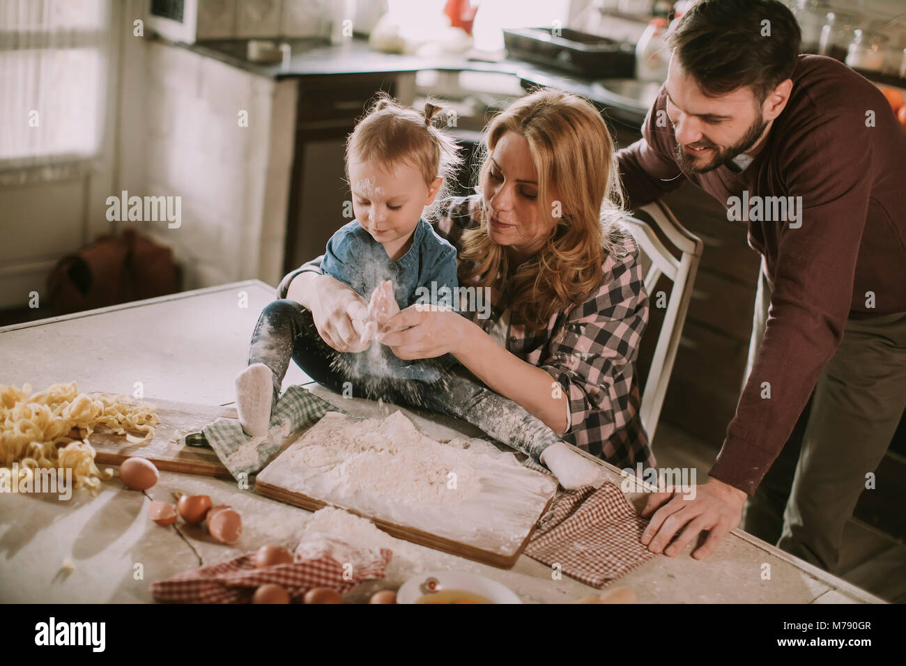 Happy family making pasta in the kitchen at home Stock Photo - Alamy