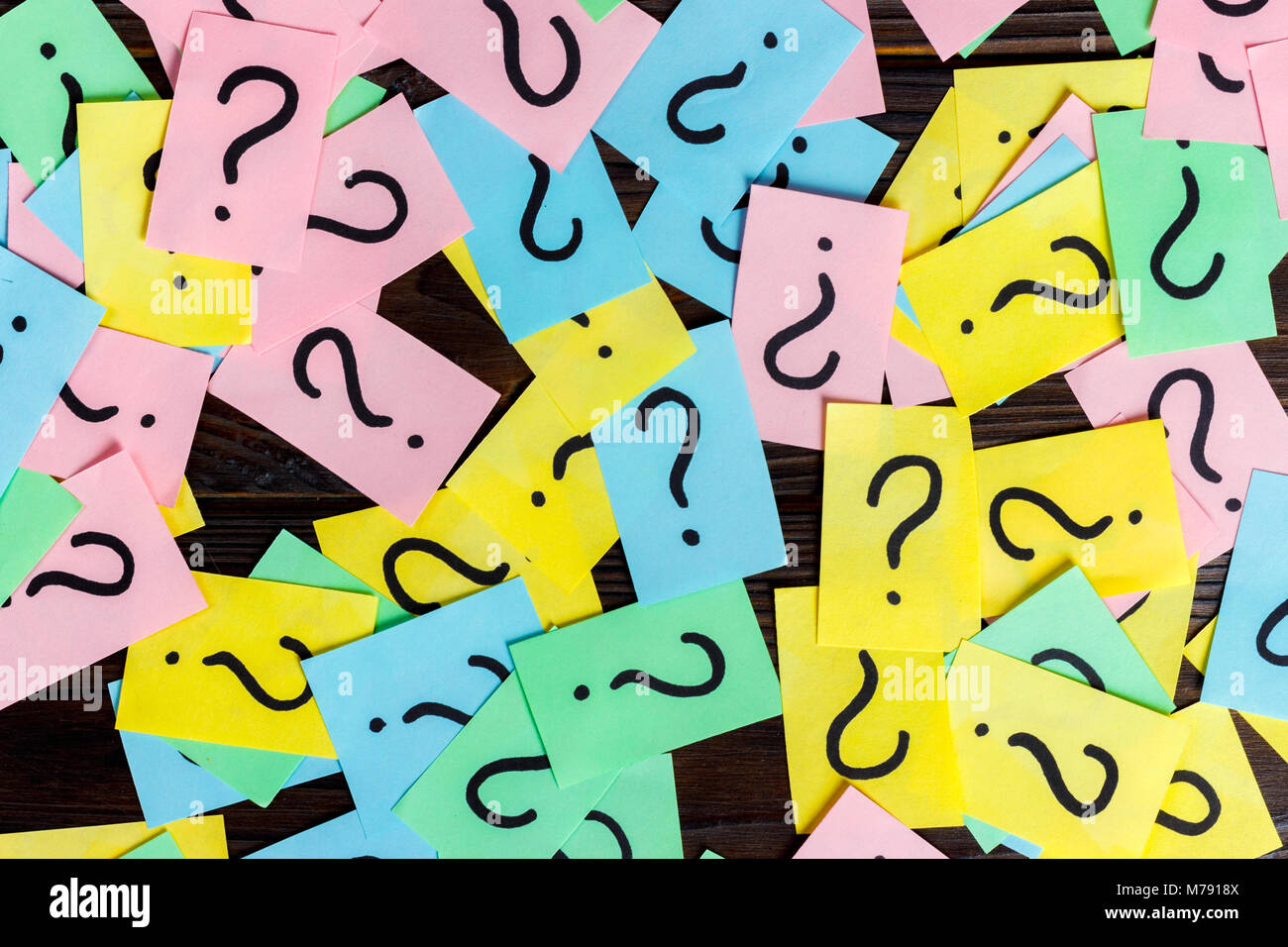 Too Many Questions on wooden background. Pile of colorful paper notes ...