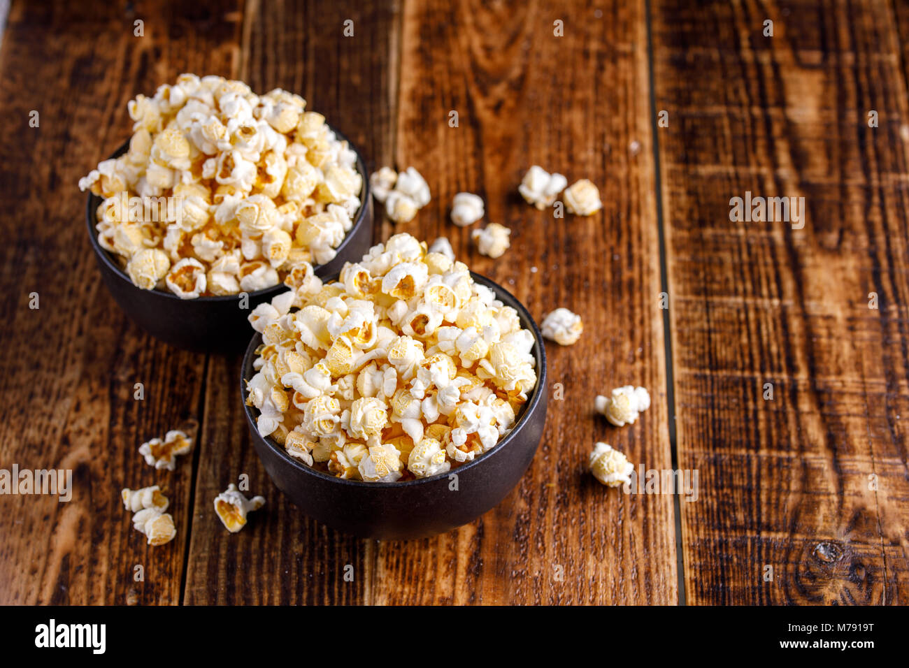 Two exquisite ceramic bowls with fresh popcorn. Still-life on a wooden ...