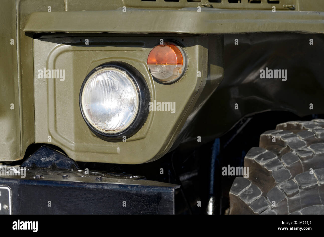 A headlight on a military truck.In the dark, the headlight illuminates ...