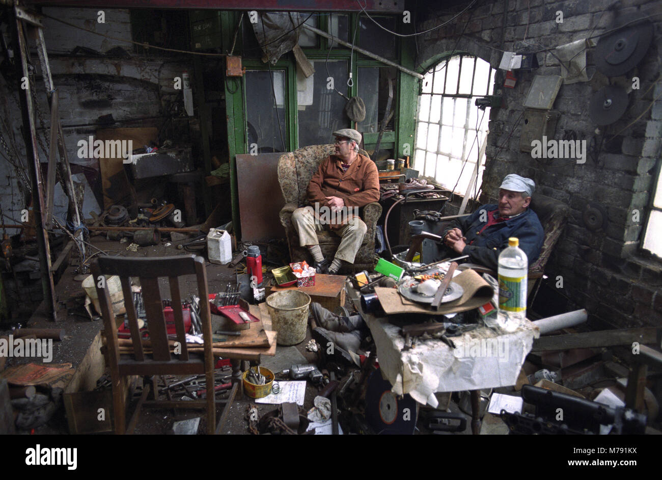 Engineers taking a lunch break in their workshop 1980s Stock Photo - Alamy
