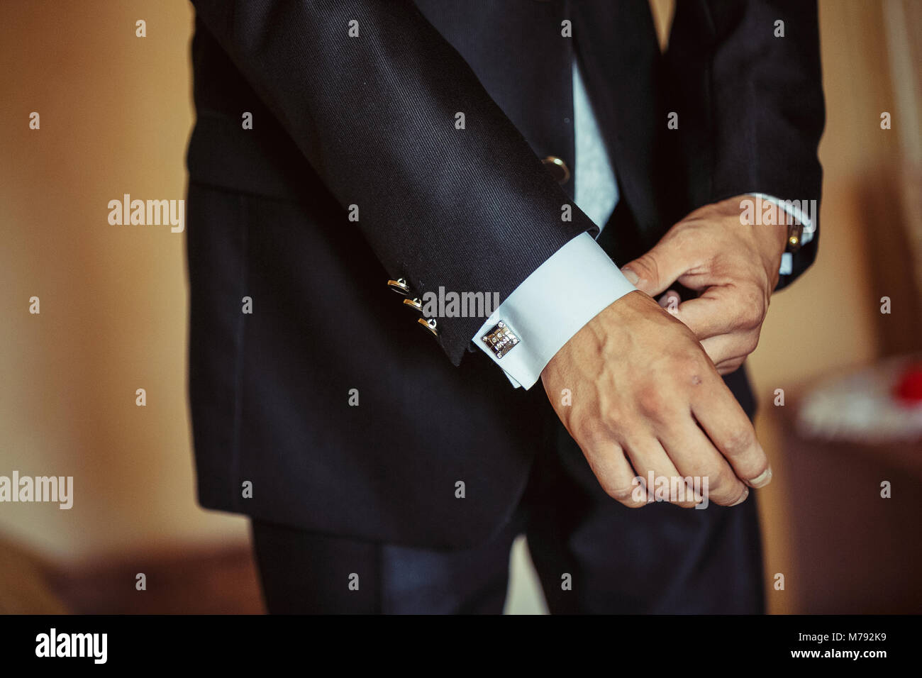 The man fastens the cuffs of his shirt Stock Photo - Alamy