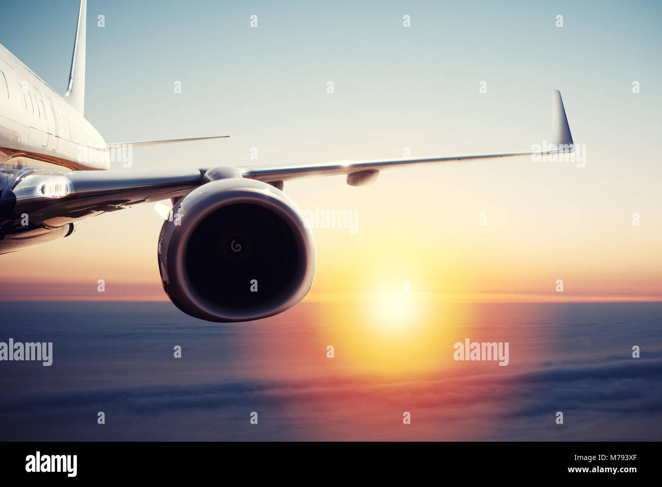 Aircraft flight over the clouds during sunrise Stock Photo - Alamy