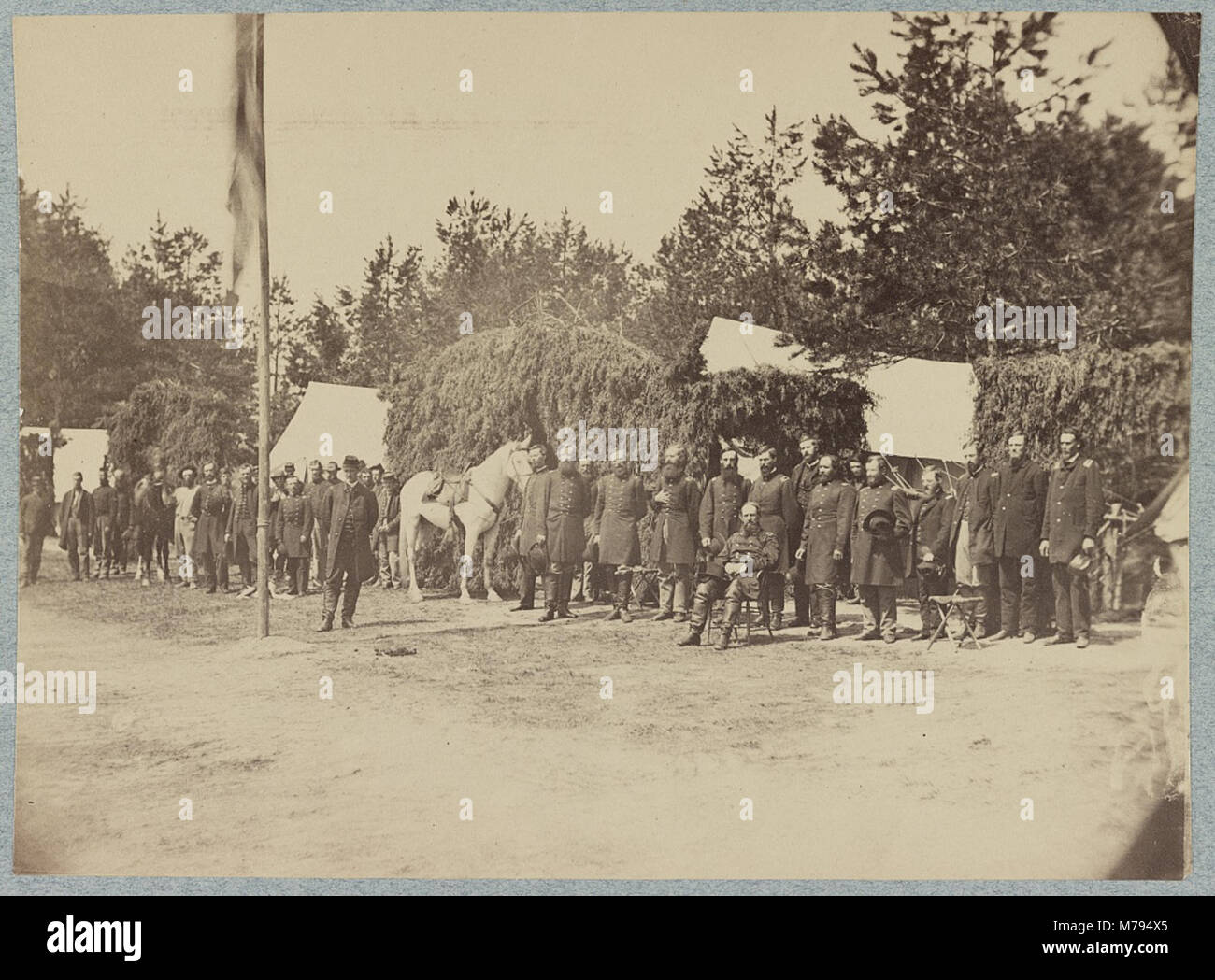 The image shows officers standing in line next to a flagpole, likely in ...