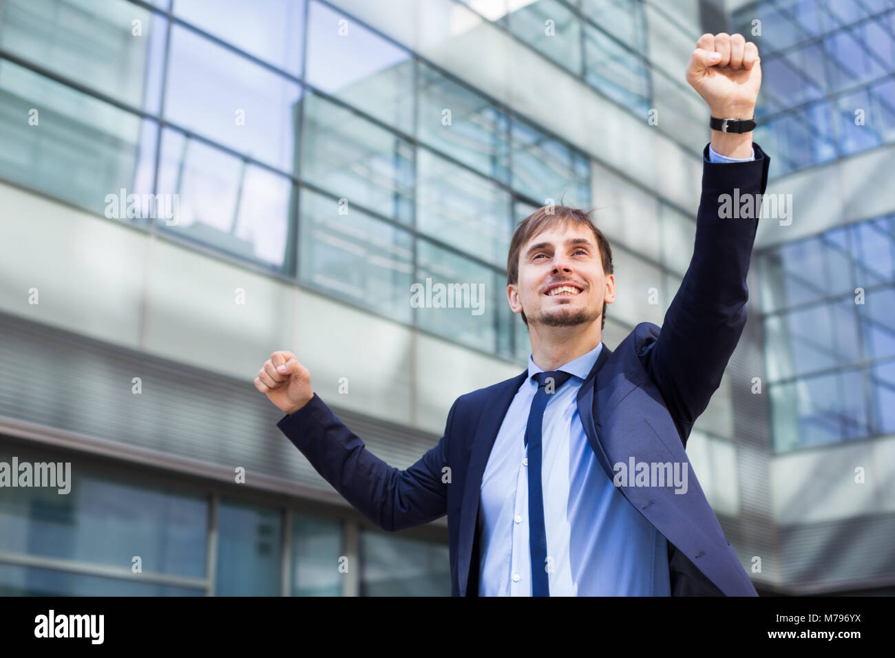 Portrait of smiling man in suit joying to success outdoors Stock Photo ...