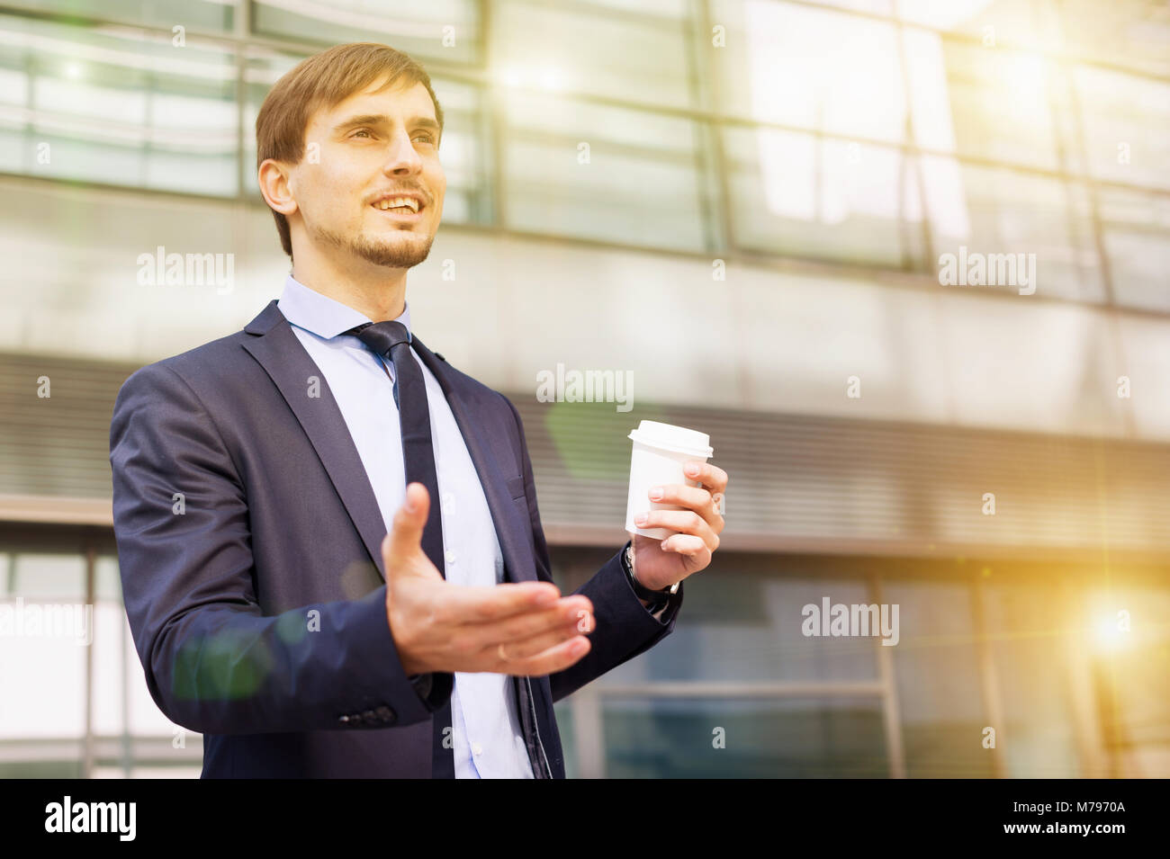 Portrait of cheerful male standing outdoor drinking coffee Stock Photo ...