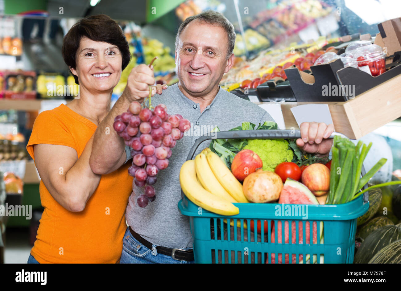 Happy family standing with basket with vegetables and fruits in food ...