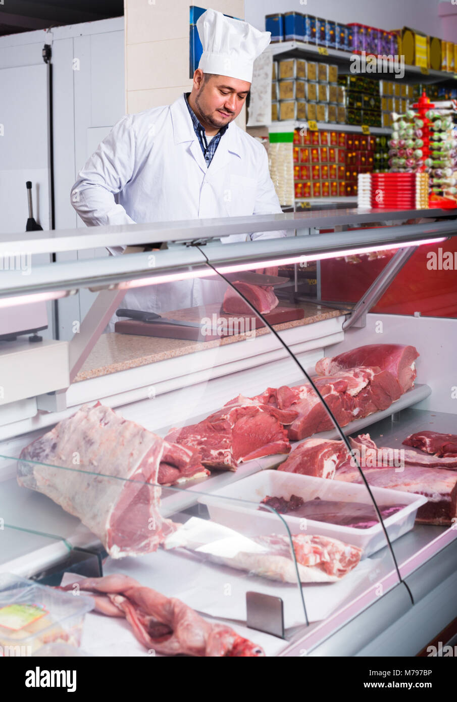 Professional butcher cutting fresh lamb meat in workshop Stock Photo ...